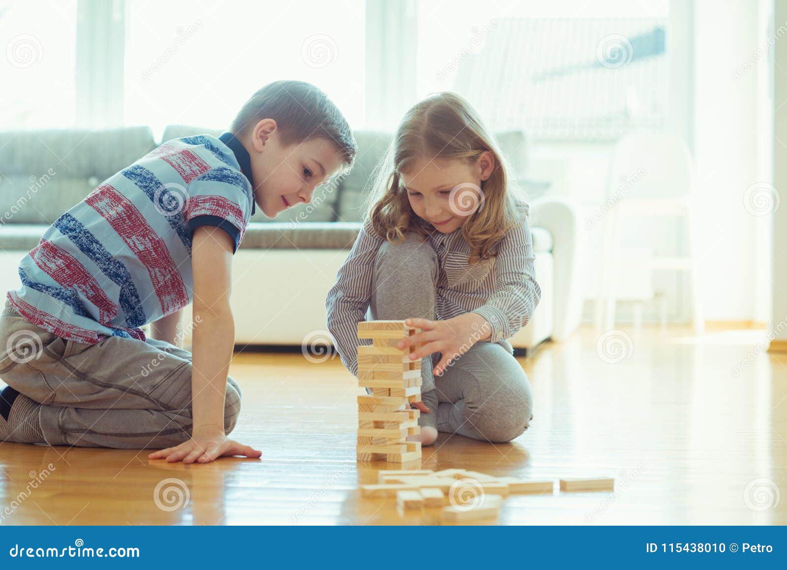 Two Happy Siblings Playing a Game with Wooden Blocks at Home Stock ...