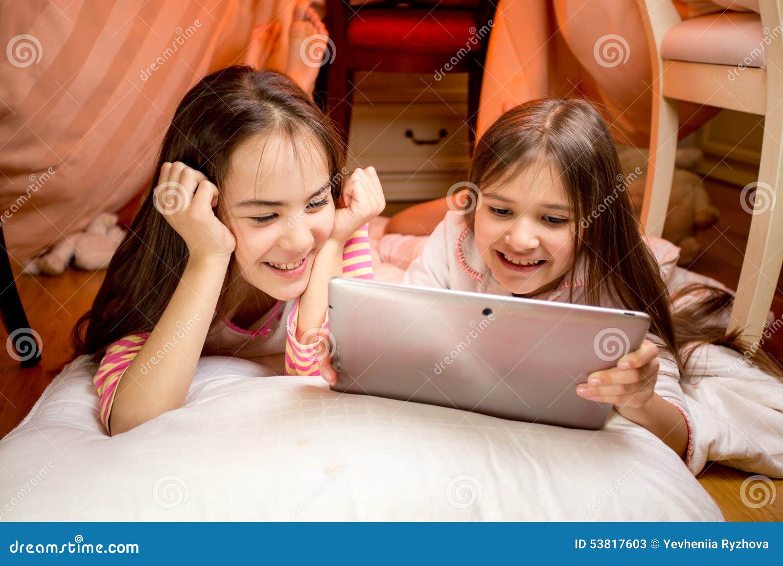 Two Happy Smiling Girls Lying on Floor and Using Digital Tablet Stock ...