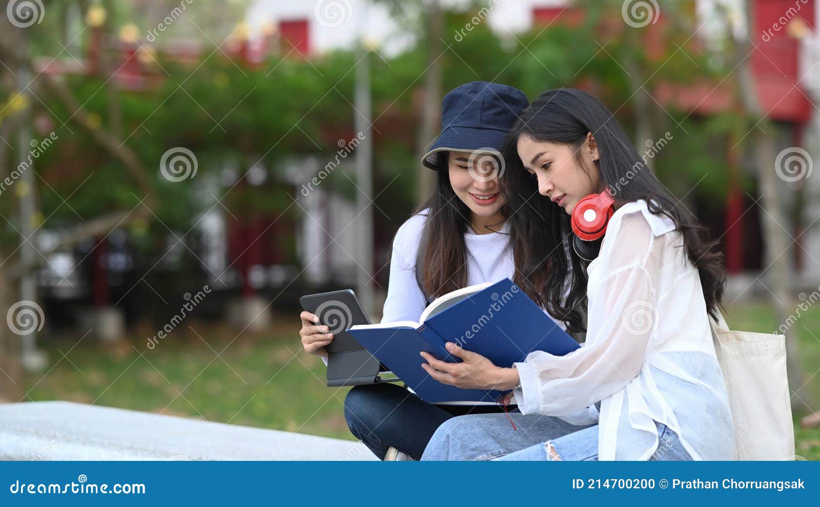 Two Students Reading Book and Talking Each Other in Campus. Stock Photo ...