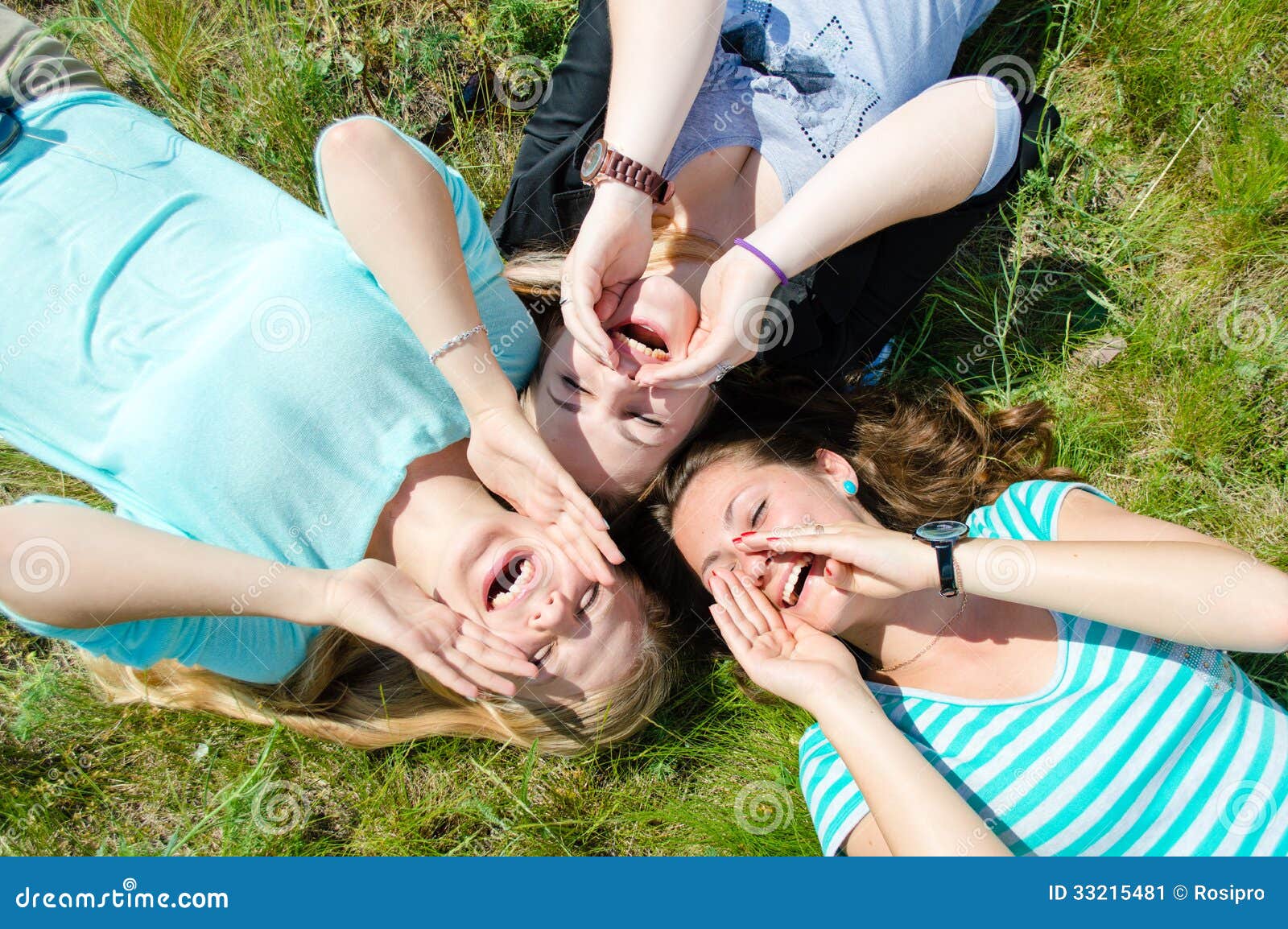 Two Happy Teen Girls Lying On Green Grass And Holding Hands Stock Image