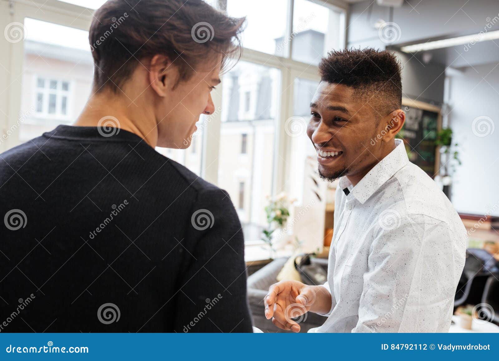 Two Happy Young Students Standing in Library and Talking. Stock Photo ...