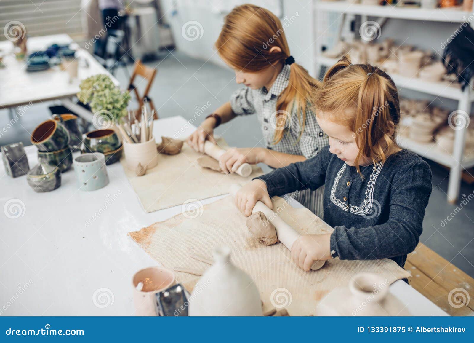 Two Hardworking Children Using a Rolling Pin while Making a Pottery ...