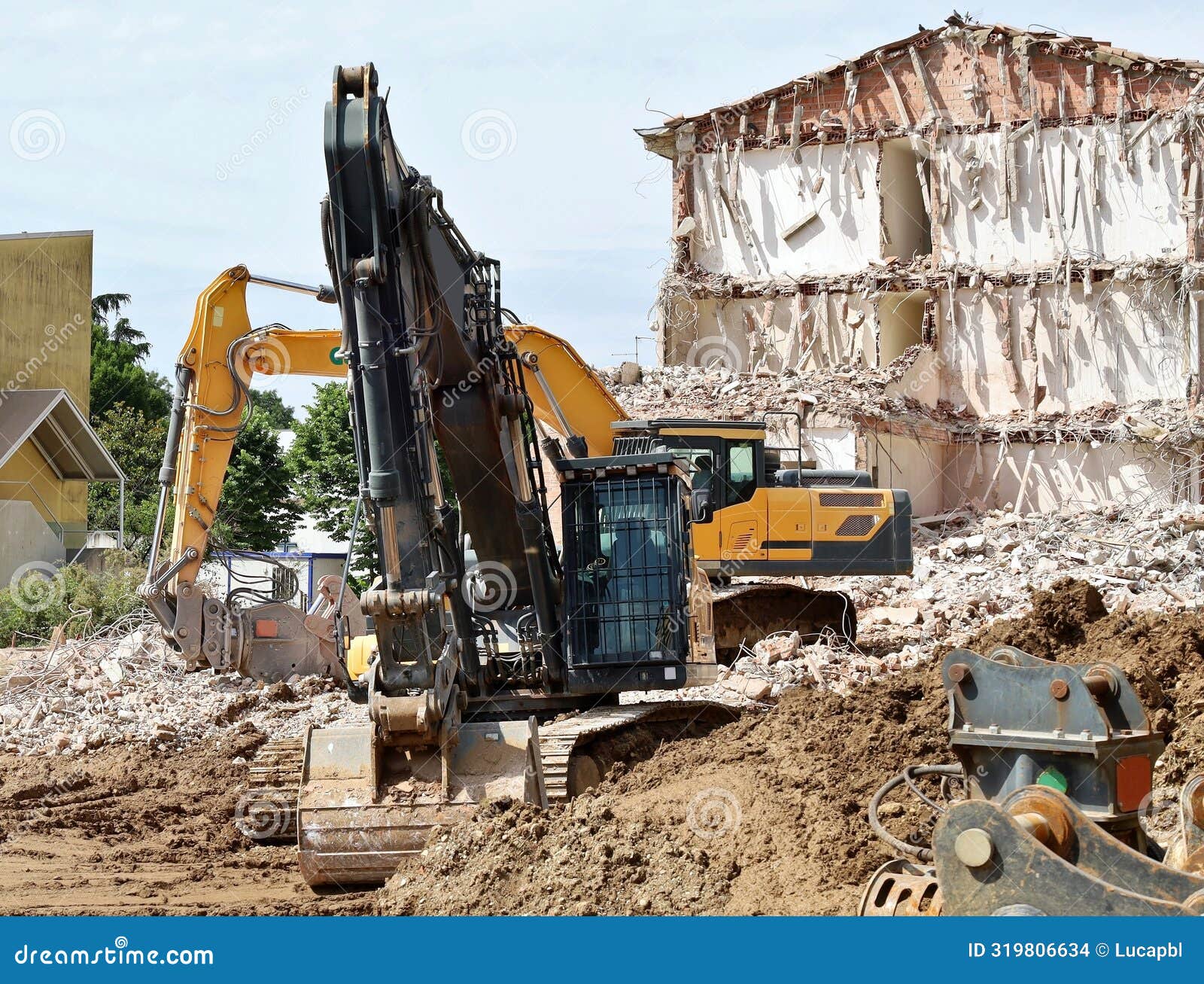 Two Heavy Excavators with a Building Under Demolition on Behind Stock ...