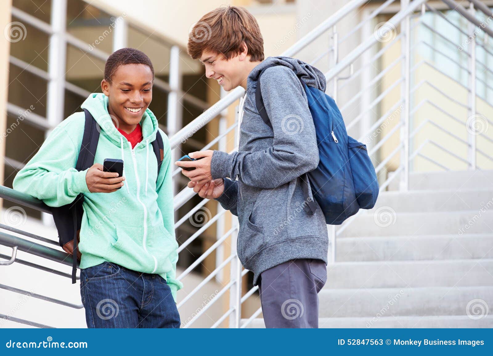 Two High School Students Outside Building with Mobiles Stock Image ...