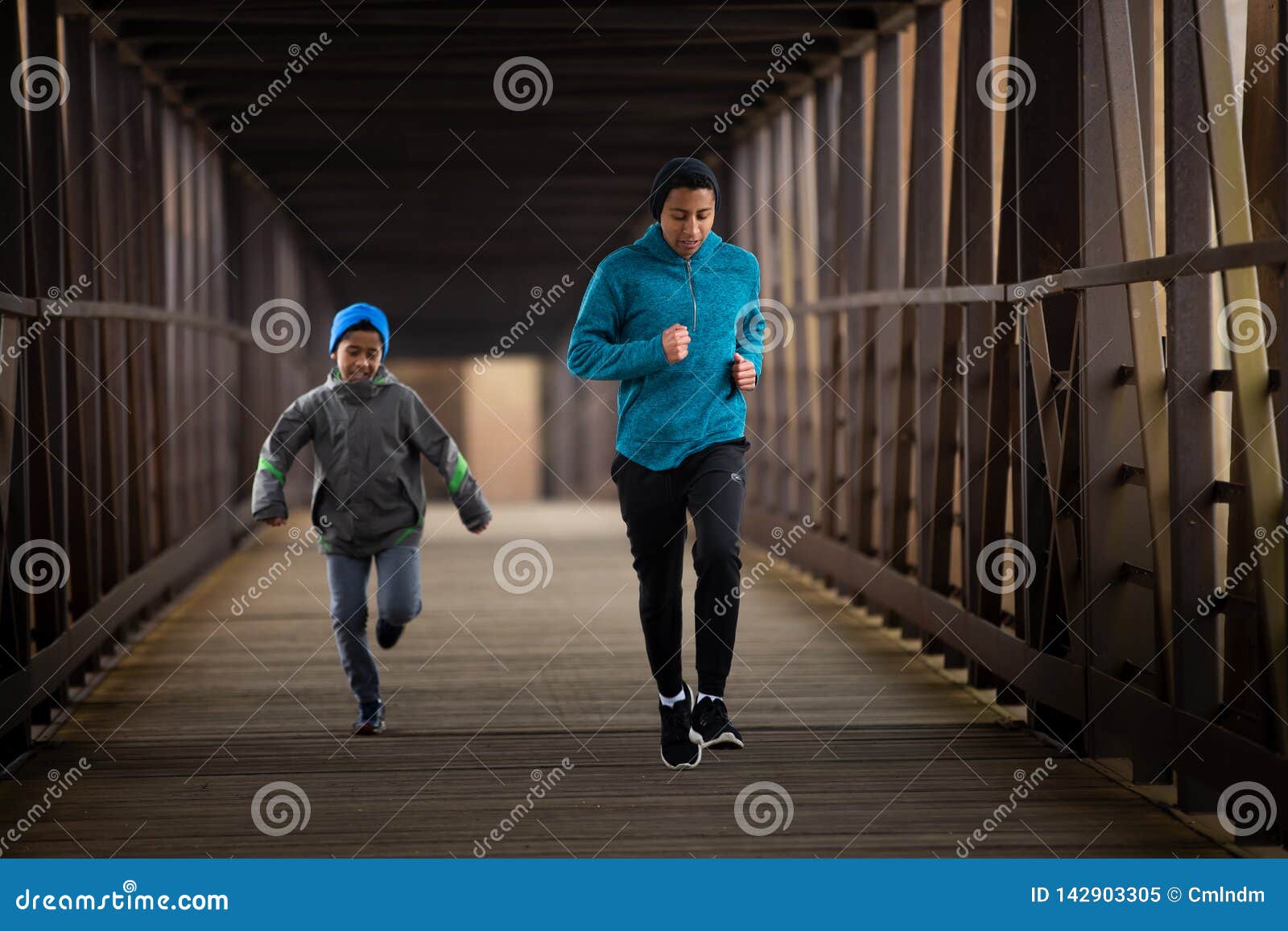 Two Hispanic Brothers Run a Race Down Bridge Stock Image - Image of ...