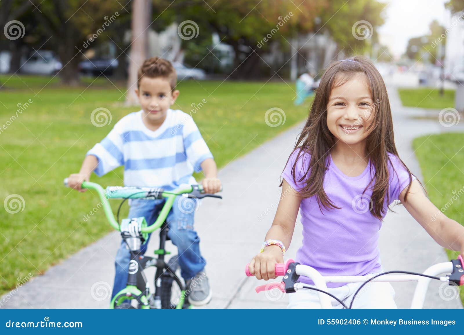 Two Hispanic Children Riding Bikes in Park Stock Photo - Image of ...
