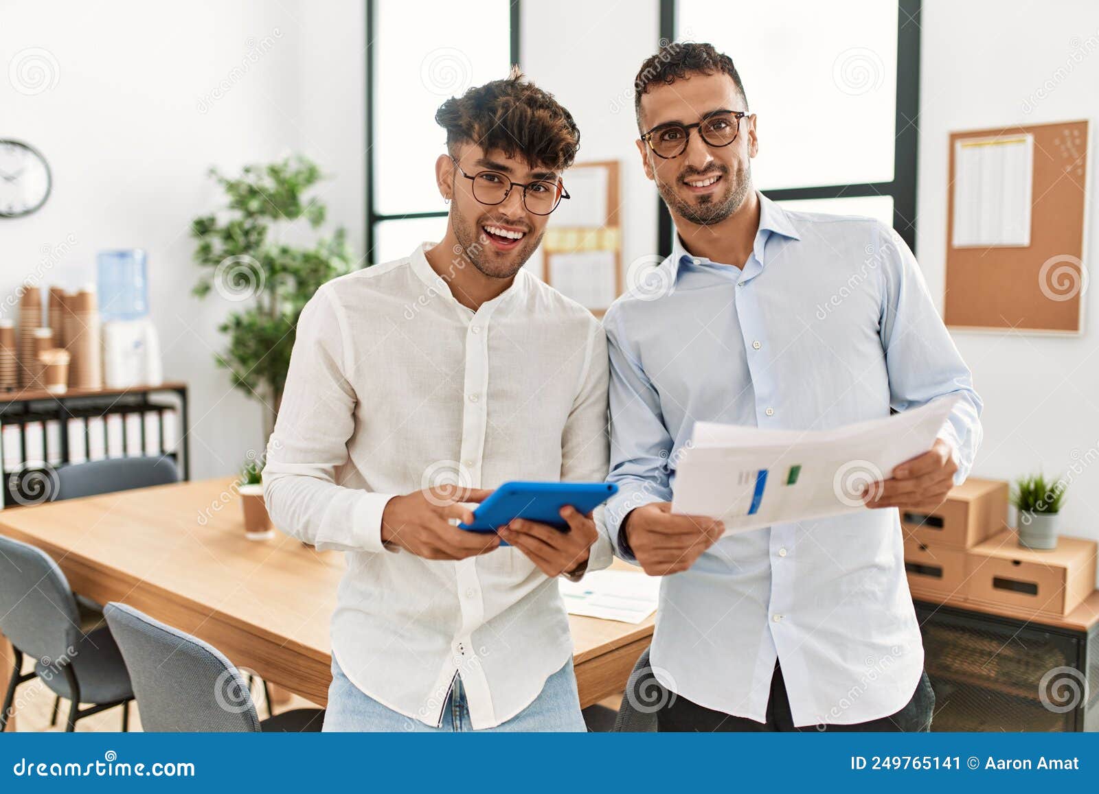 Two Hispanic Men Business Workers Using Touchpad Reading Documents ...