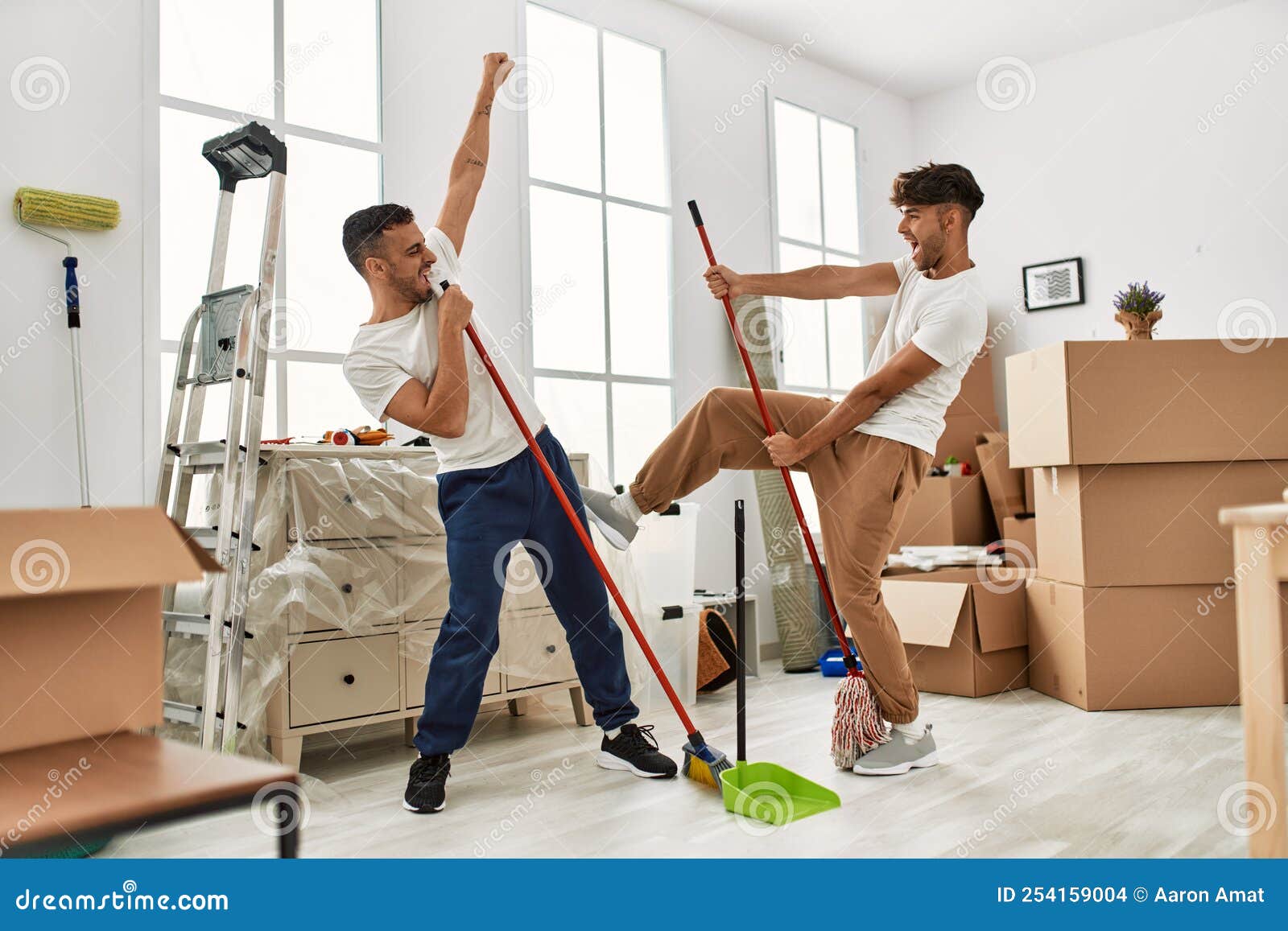 Two Hispanic Men Couple Cleaning and Dancing at New Home Stock Photo ...