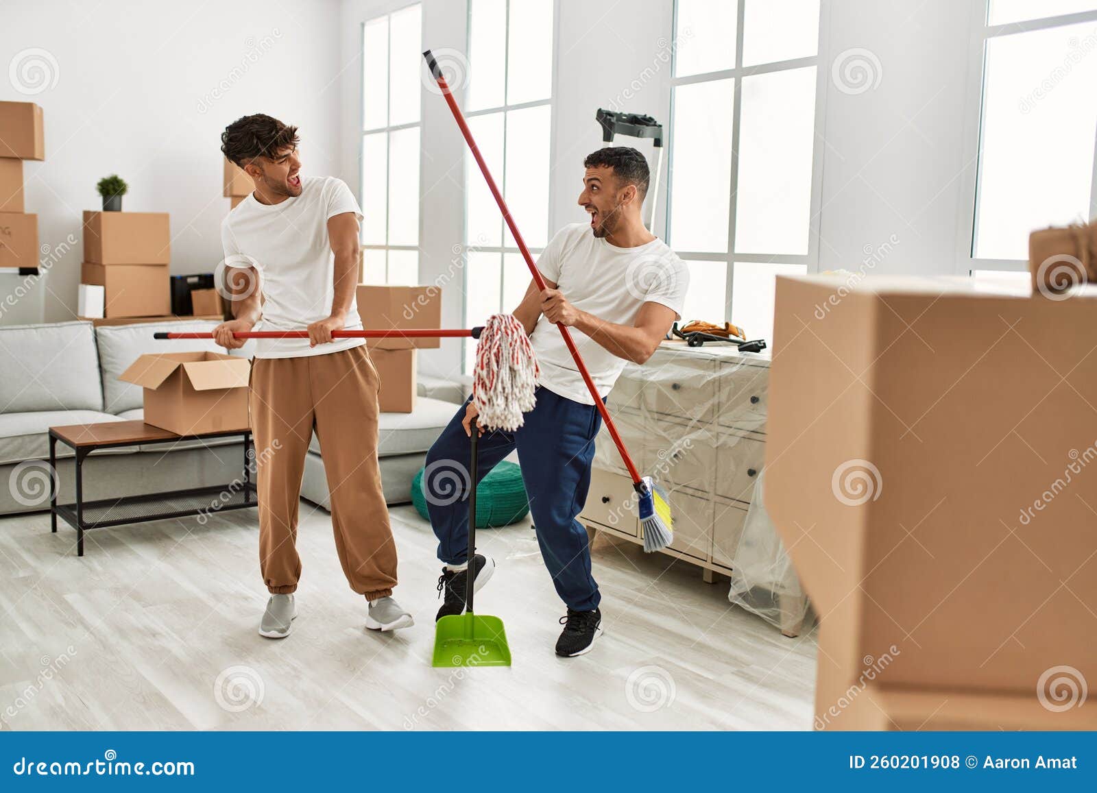 Two Hispanic Men Couple Cleaning and Dancing at New Home Stock Photo ...