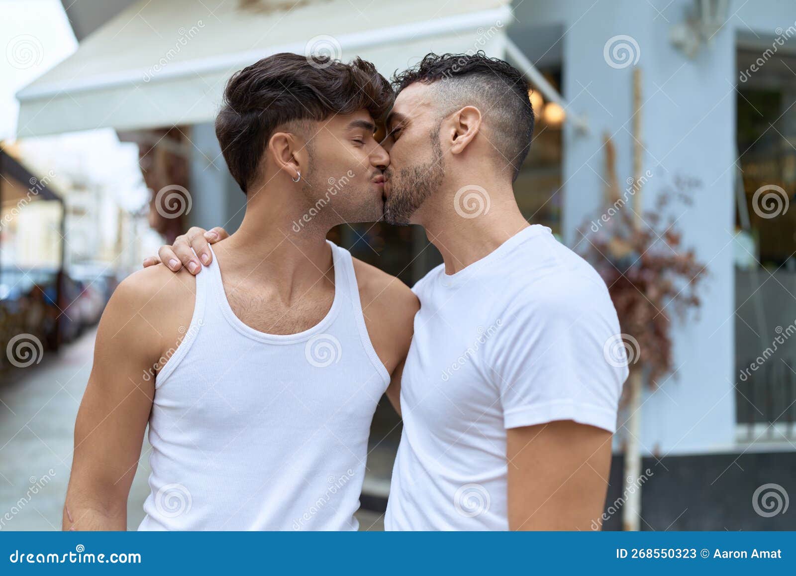 Two Hispanic Men Couple Hugging Each Other And Kissing At Coffee Shop