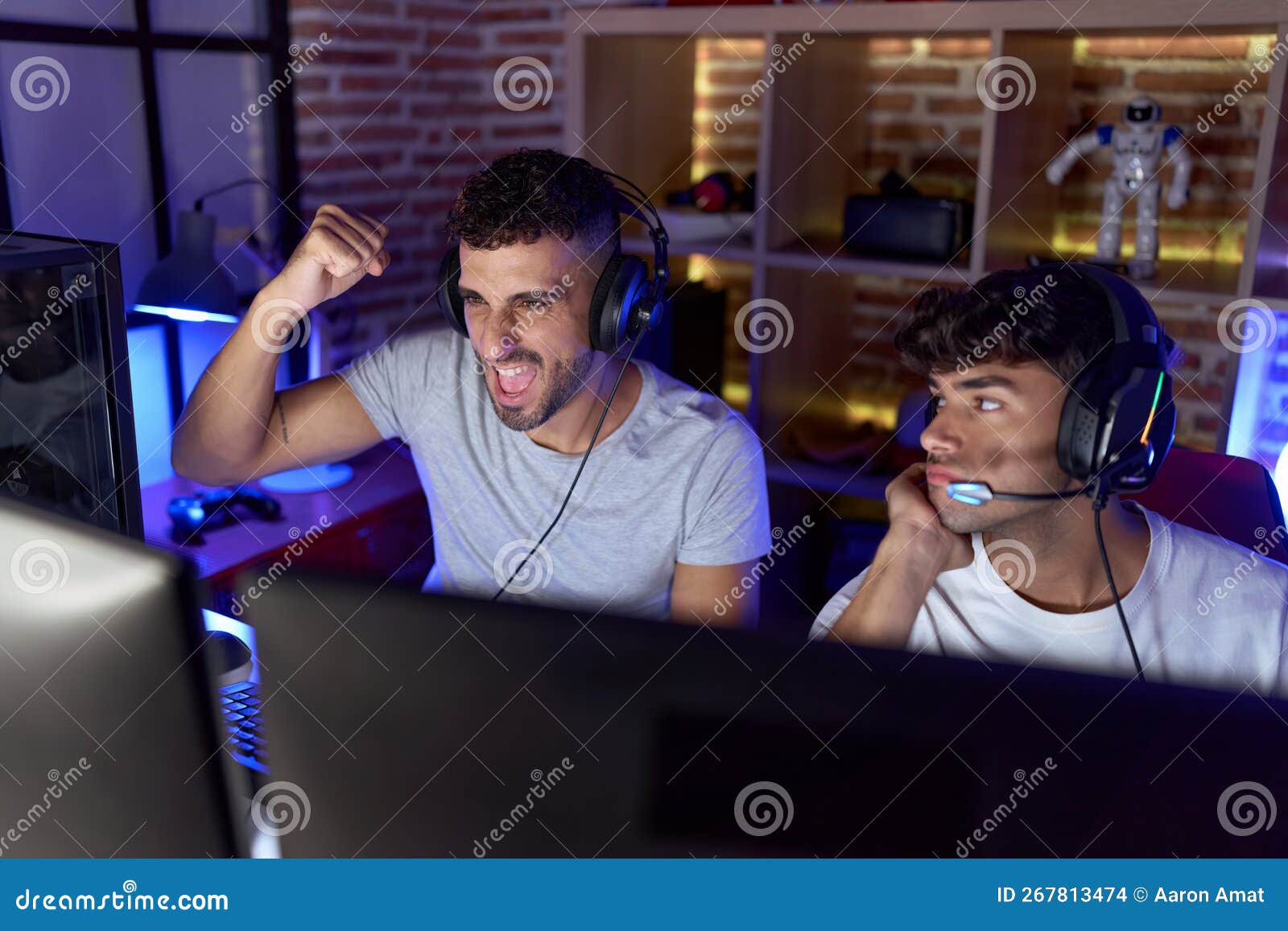 Two Hispanic Men Streamers Playing Video Game with Winner Expression at ...