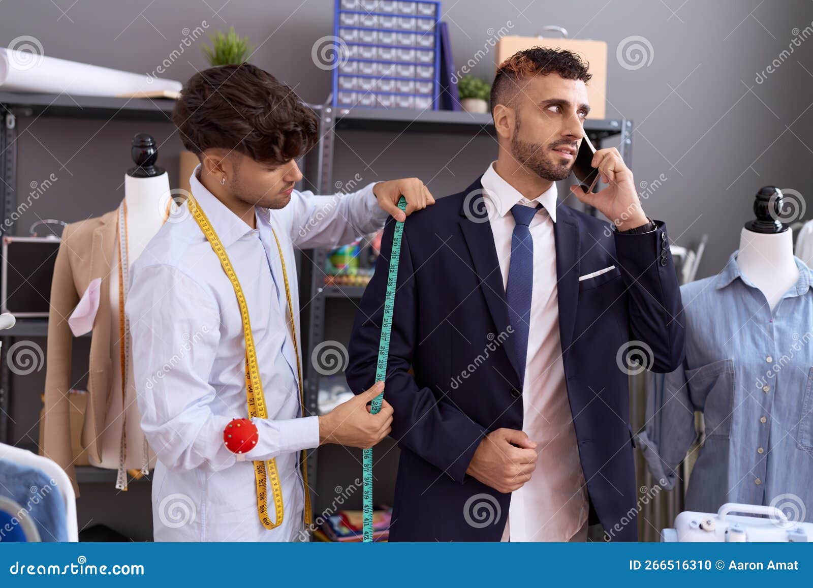 Two Hispanic Men Tailor Measuring Sleeve Jacket while Client Talk on ...