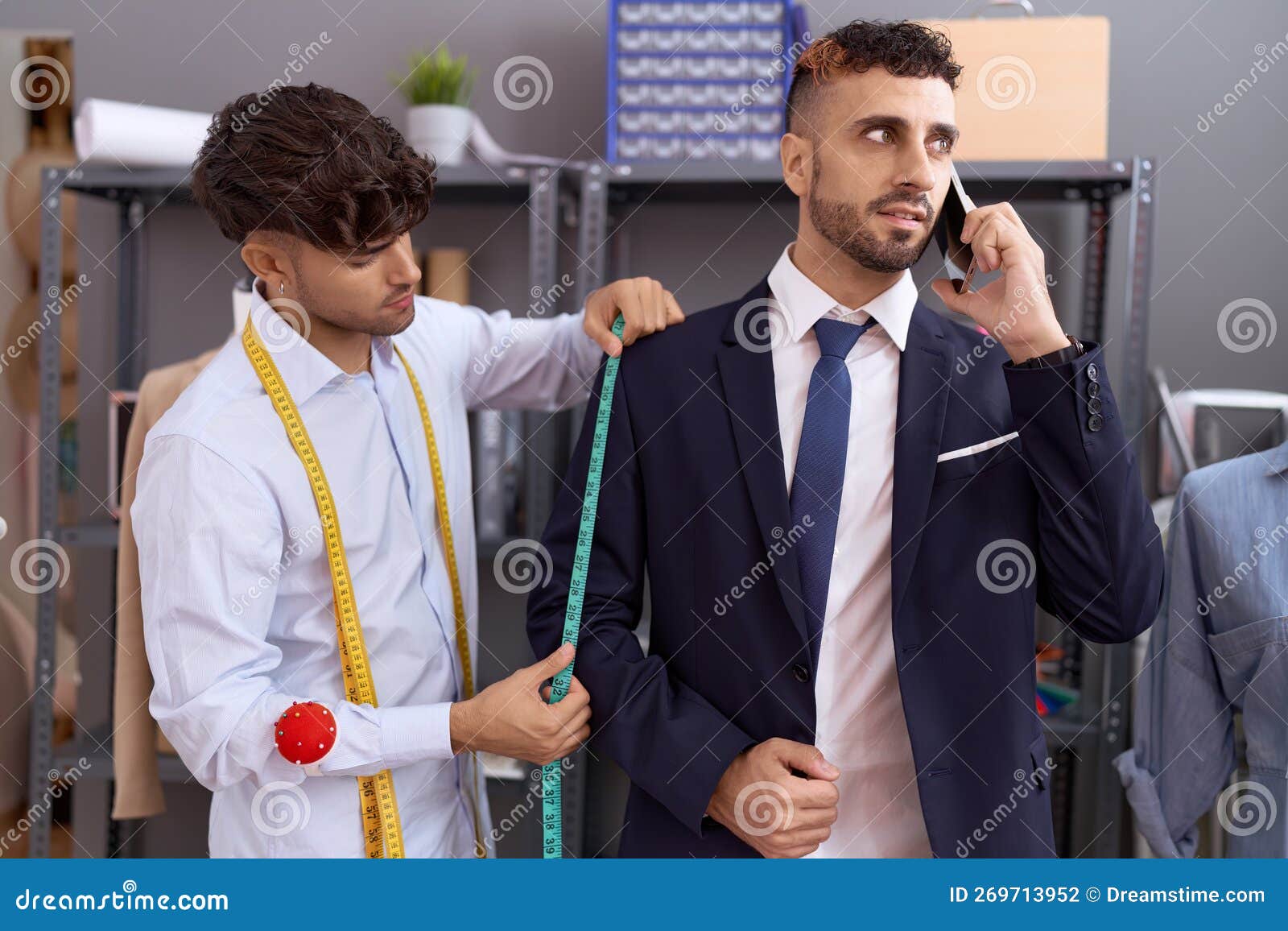 Two Hispanic Men Tailor Measuring Sleeve Jacket while Client Talk on ...