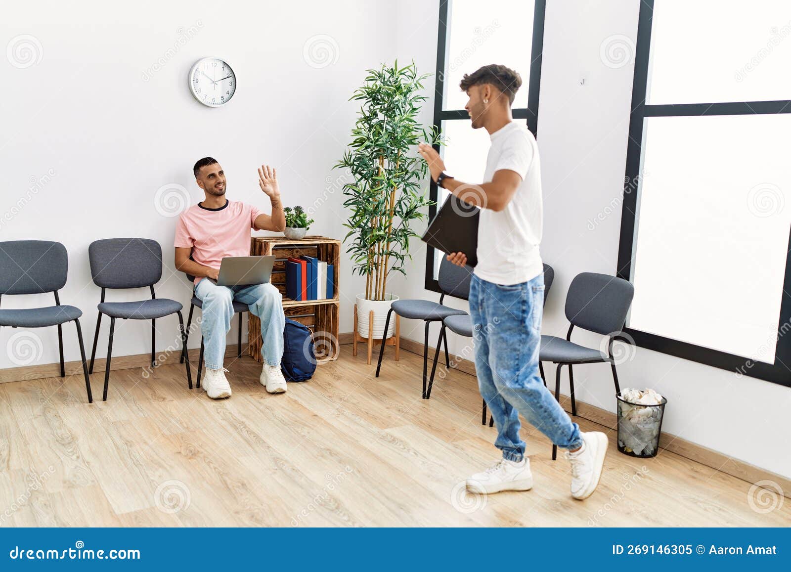 Two Hispanic Men Using Laptop Saying Bye at Waiting Room Stock Image ...