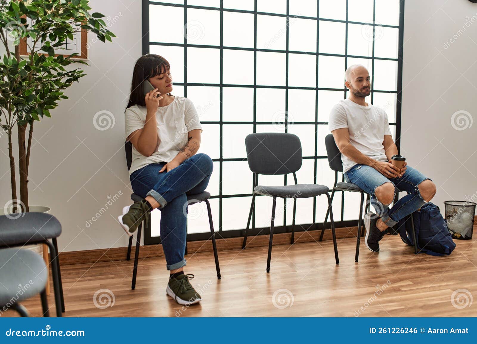 Two Hispanic Person Boring Talking on the Smartphone at Waiting Room ...
