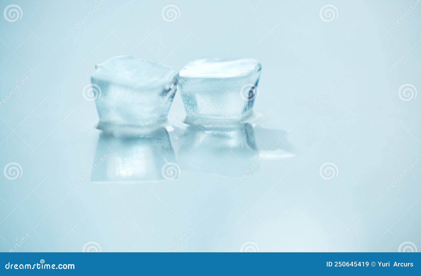 . Two Ice Blocks Melting Side by Side Against a Blue Background in ...