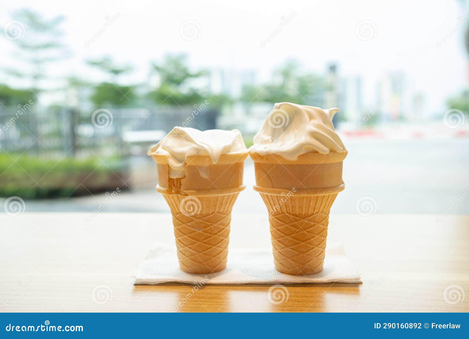 Two Ice Cream Cones with Couple of Bites on Table Horizontal ...