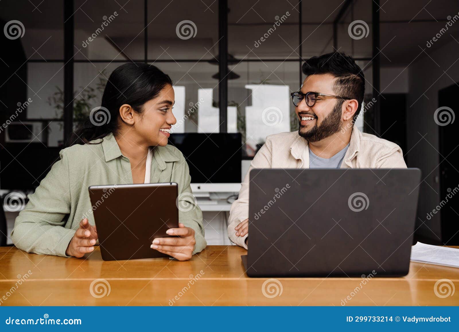 Two Indian Colleagues Using Laptop and Tablet while Working Together in ...
