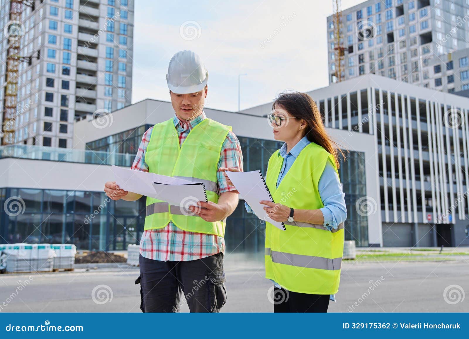 Two Industrial Construction Workers Discussing Project Plan for ...
