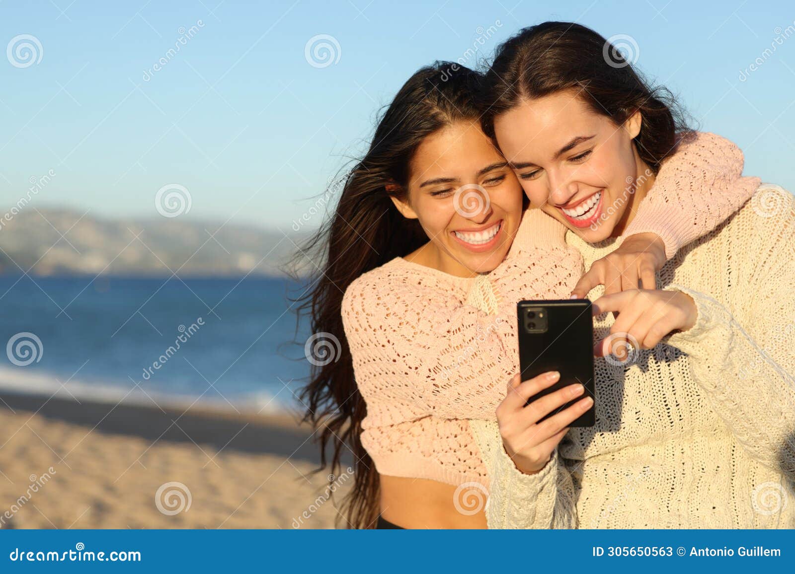 Two Joyful Friends Checking Phone on the Beach Stock Image - Image of ...