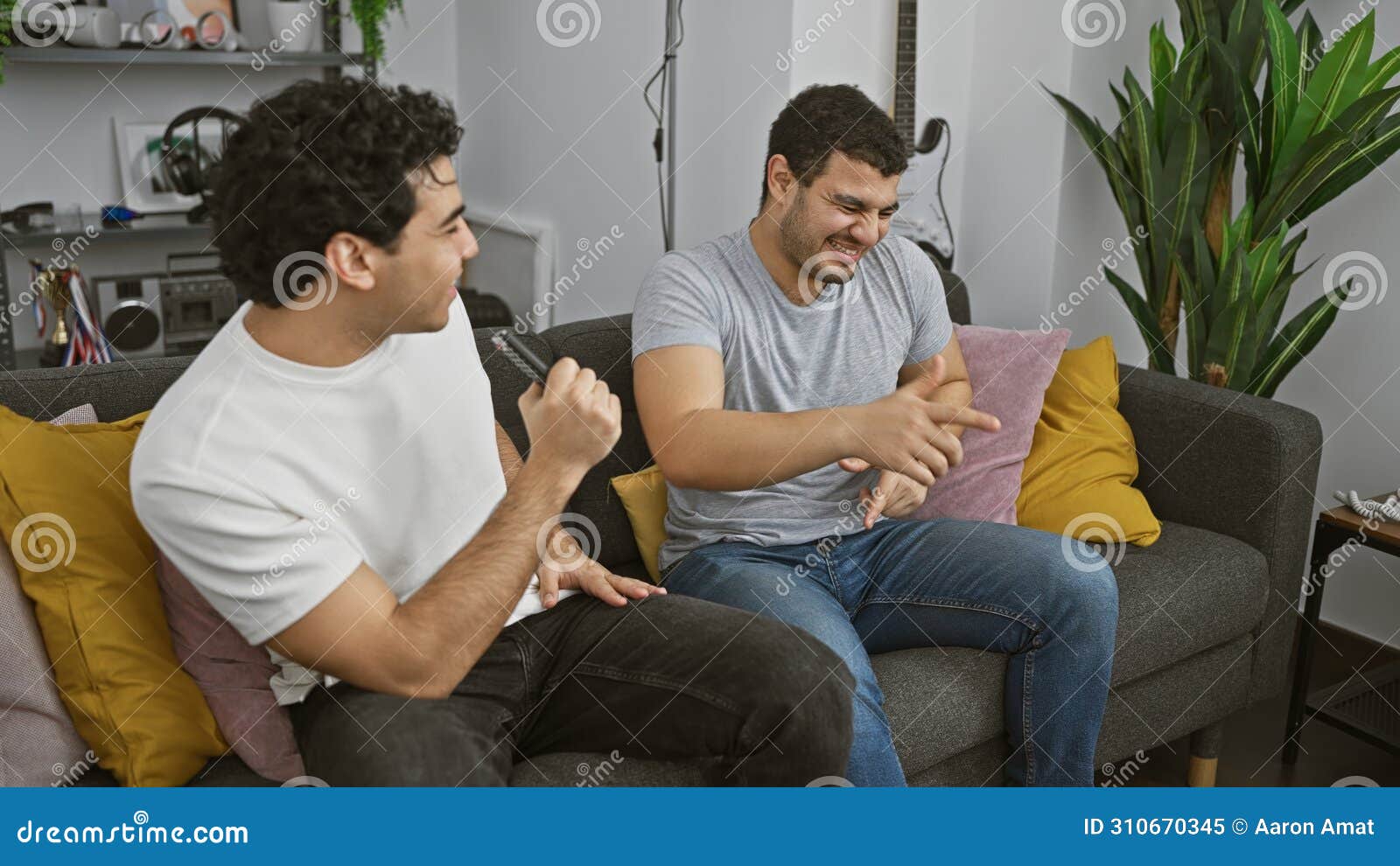 Two Joyful Men Engage in a Playful Singing Activity Indoors Using a ...