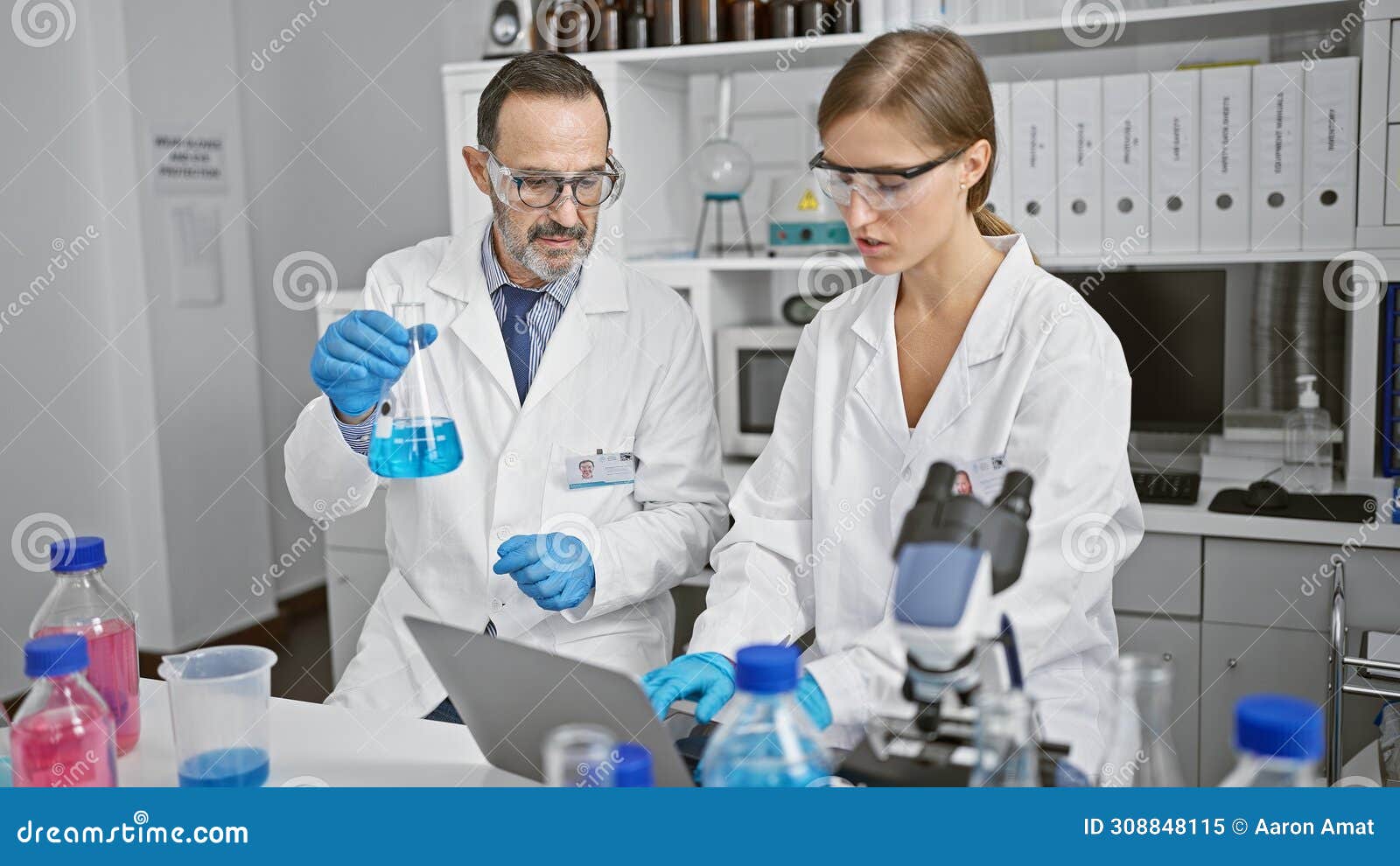 Two Jubilant Scientists Working Together in a Lab, Conversing and Using ...