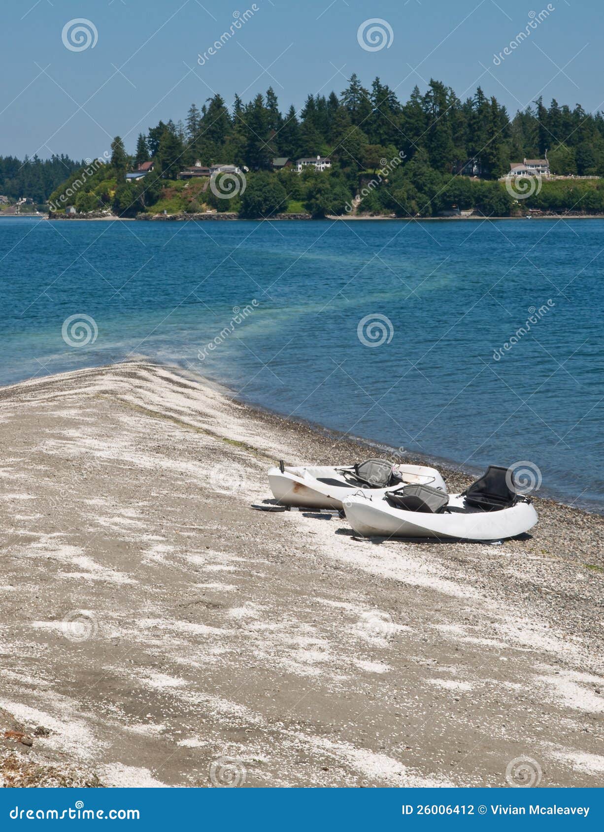 Two Kayaks on Sand Spit with Houses on Shore Stock Photo - Image of ...