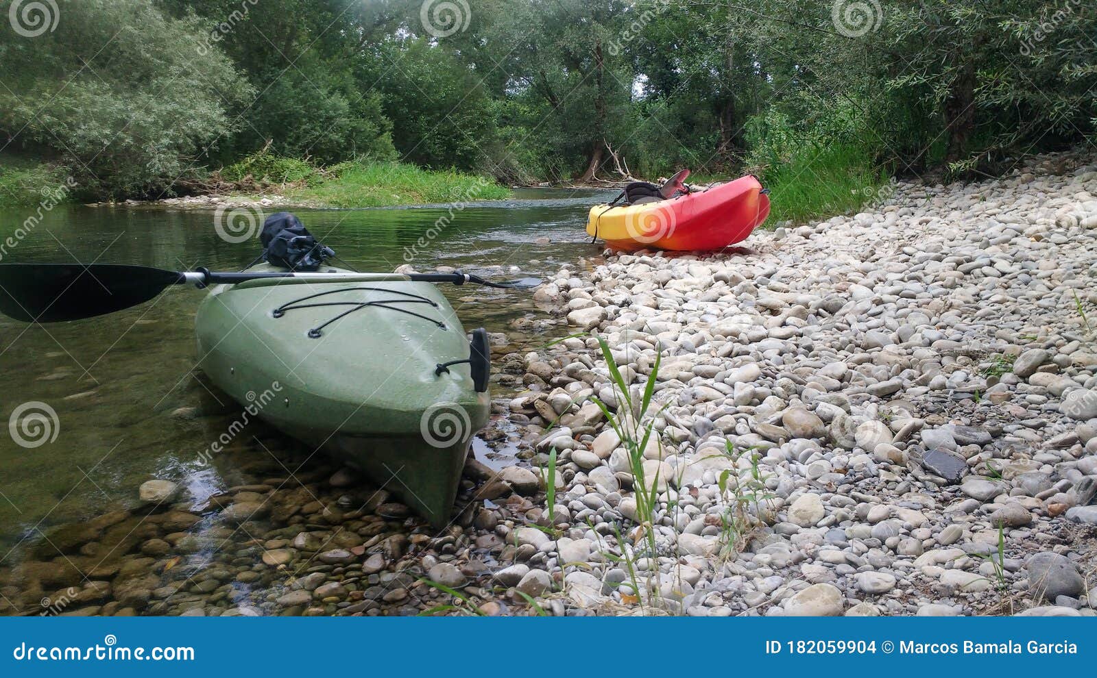 Two Kayaks on the Side of a River. There are Trees Around and Rocks on ...