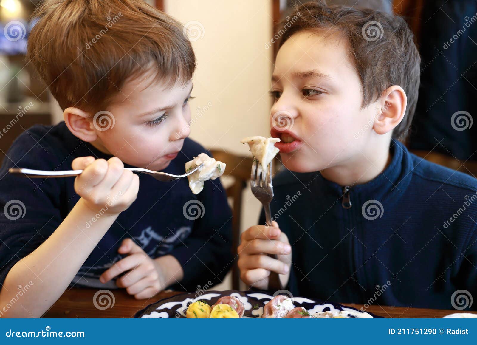 Two kids eating dumplings stock photo. Image of dinner - 211751290
