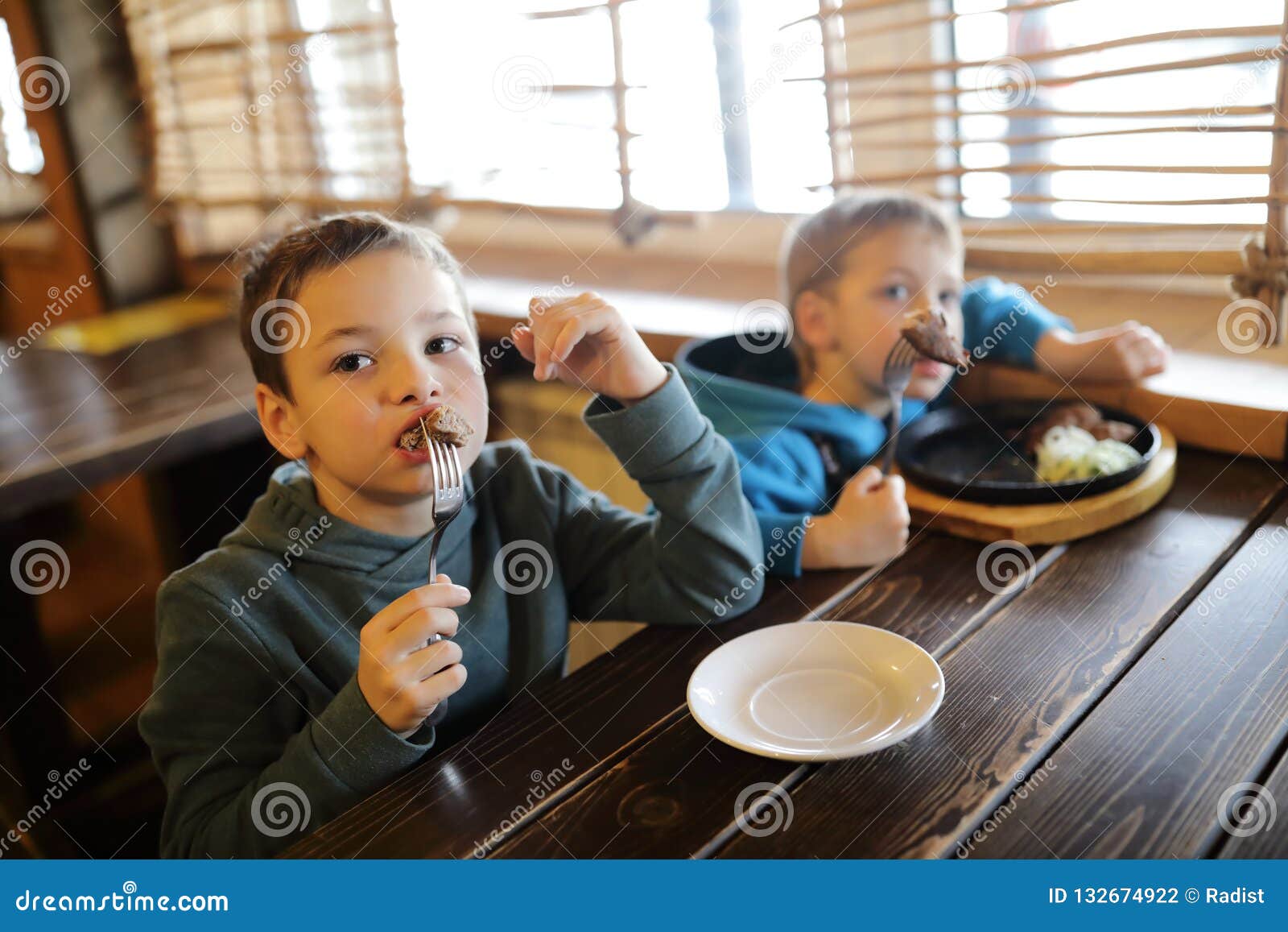 Two kids have lunch stock photo. Image of dish, holding - 132674922