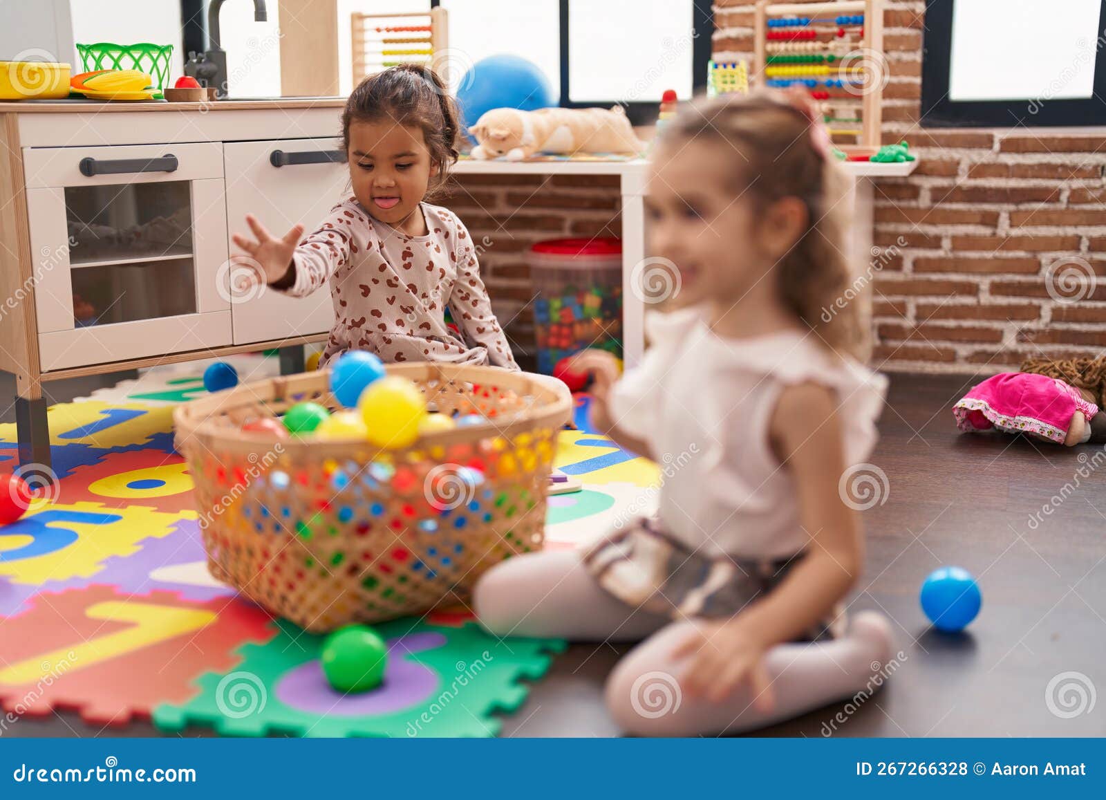 Two Kids Playing with Balls Sitting on Floor at Kindergarten Stock ...