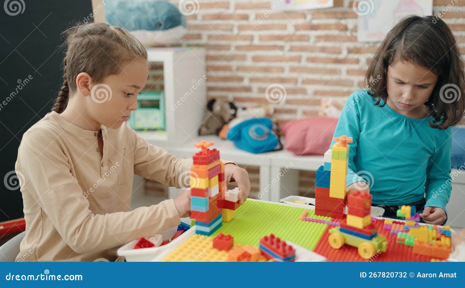 Two Kids Playing with Construction Blocks Sitting on Table at ...