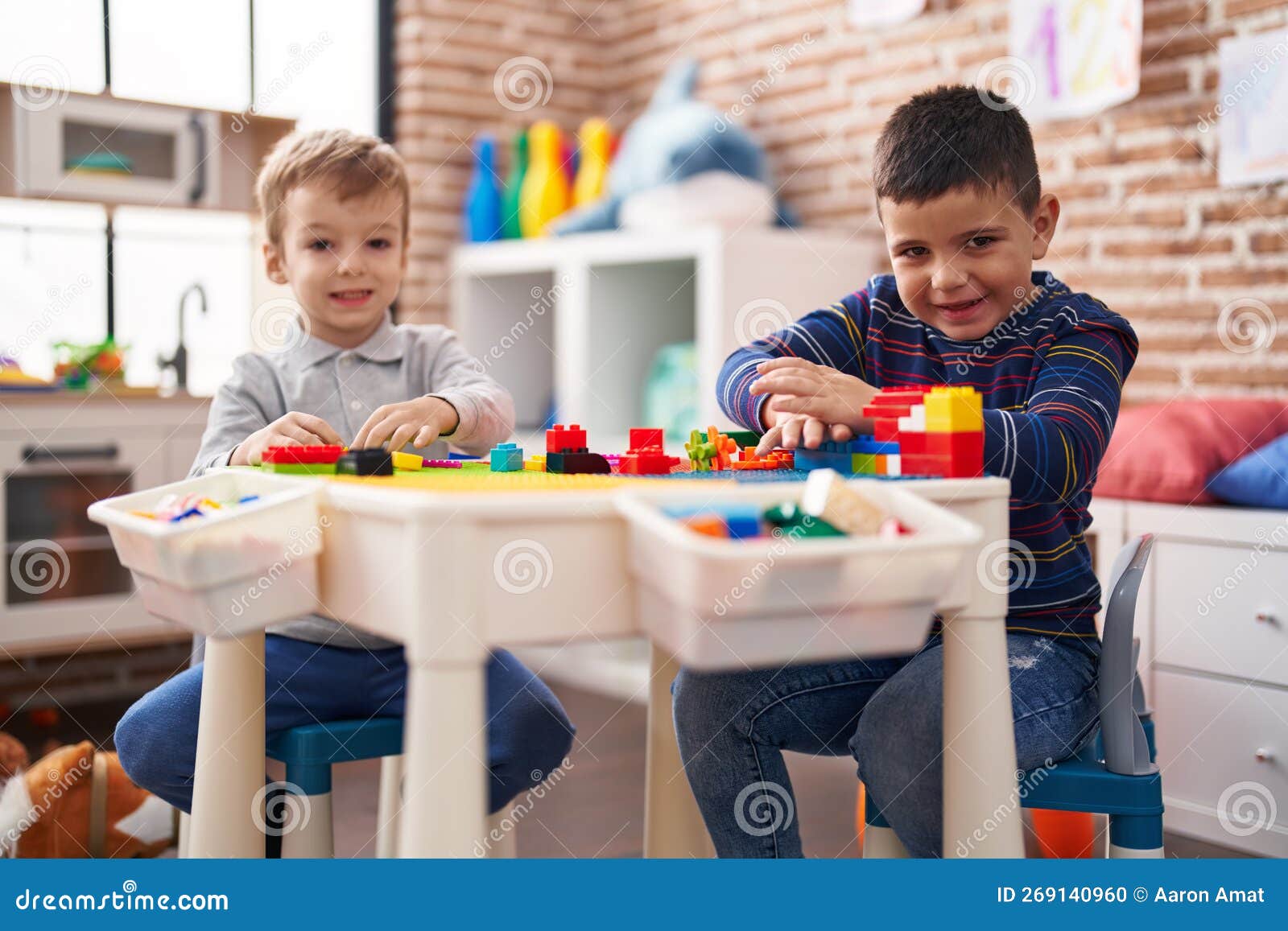 Two Kids Playing with Construction Blocks Sitting on Table at ...