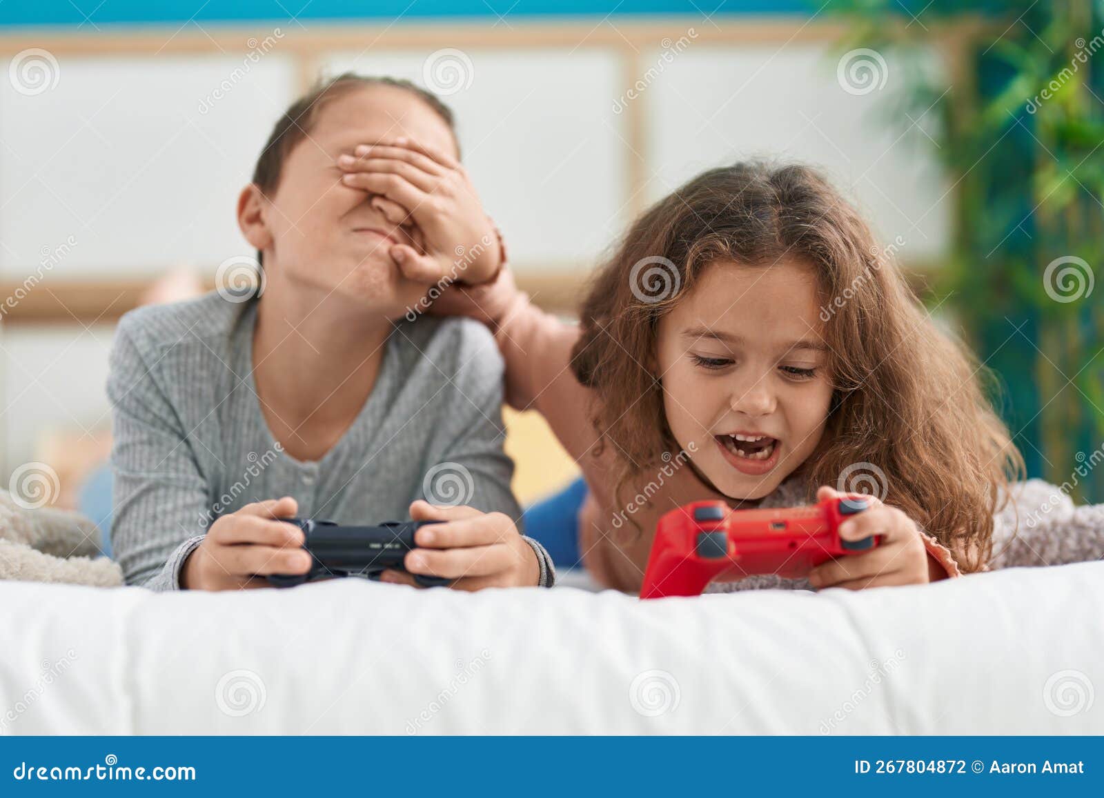 Two Kids Playing Video Game Lying on Bed Cheating at Bedroom Stock ...