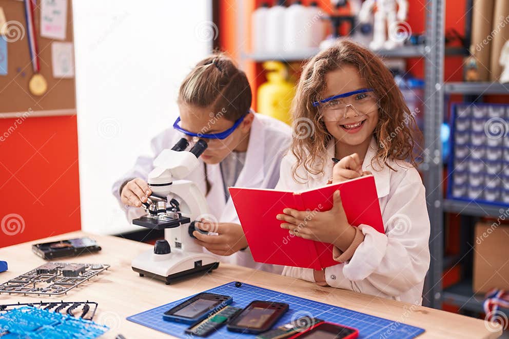 Two Kids Students Using Microscope Writing on Notebook at Laboratory ...