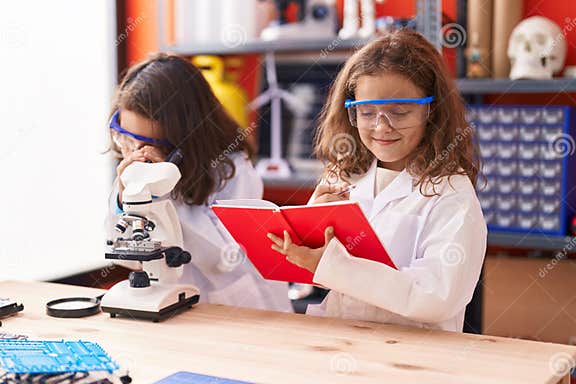 Two Kids Students Using Microscope Writing on Notebook at Laboratory ...