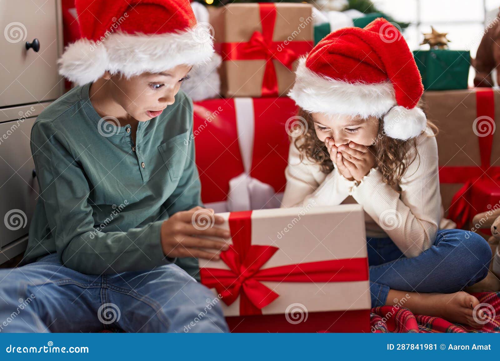 Two Kids Unpacking Gift Sitting on Floor by Christmas Tree at Home ...