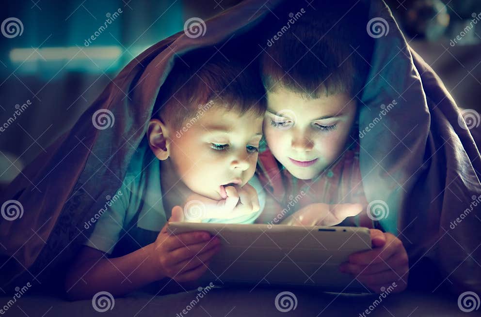 Two Kids Using Tablet Pc at Night Stock Image - Image of people, duvet ...