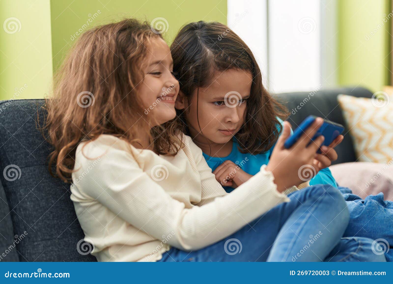 Two Kids Watching Video on Smartphone Sitting on Sofa at Home Stock ...
