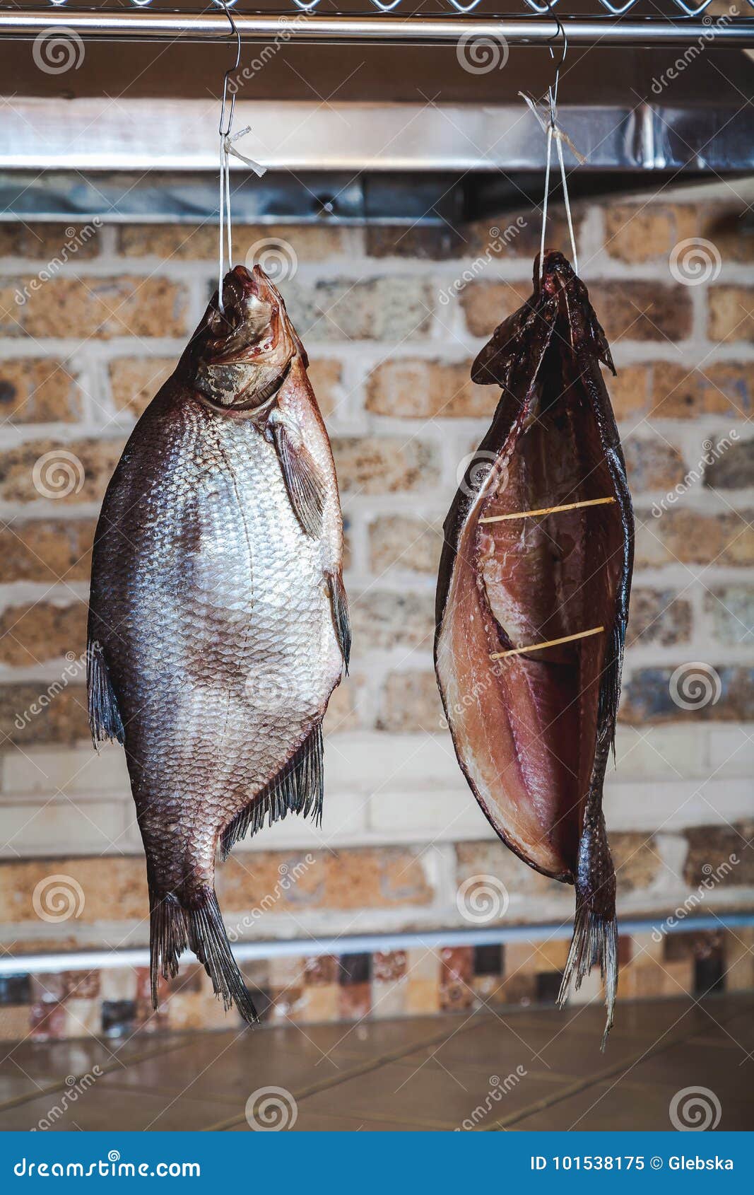 Two Large Smoked Fish Hanging on Brick Wall Background Stock Image ...