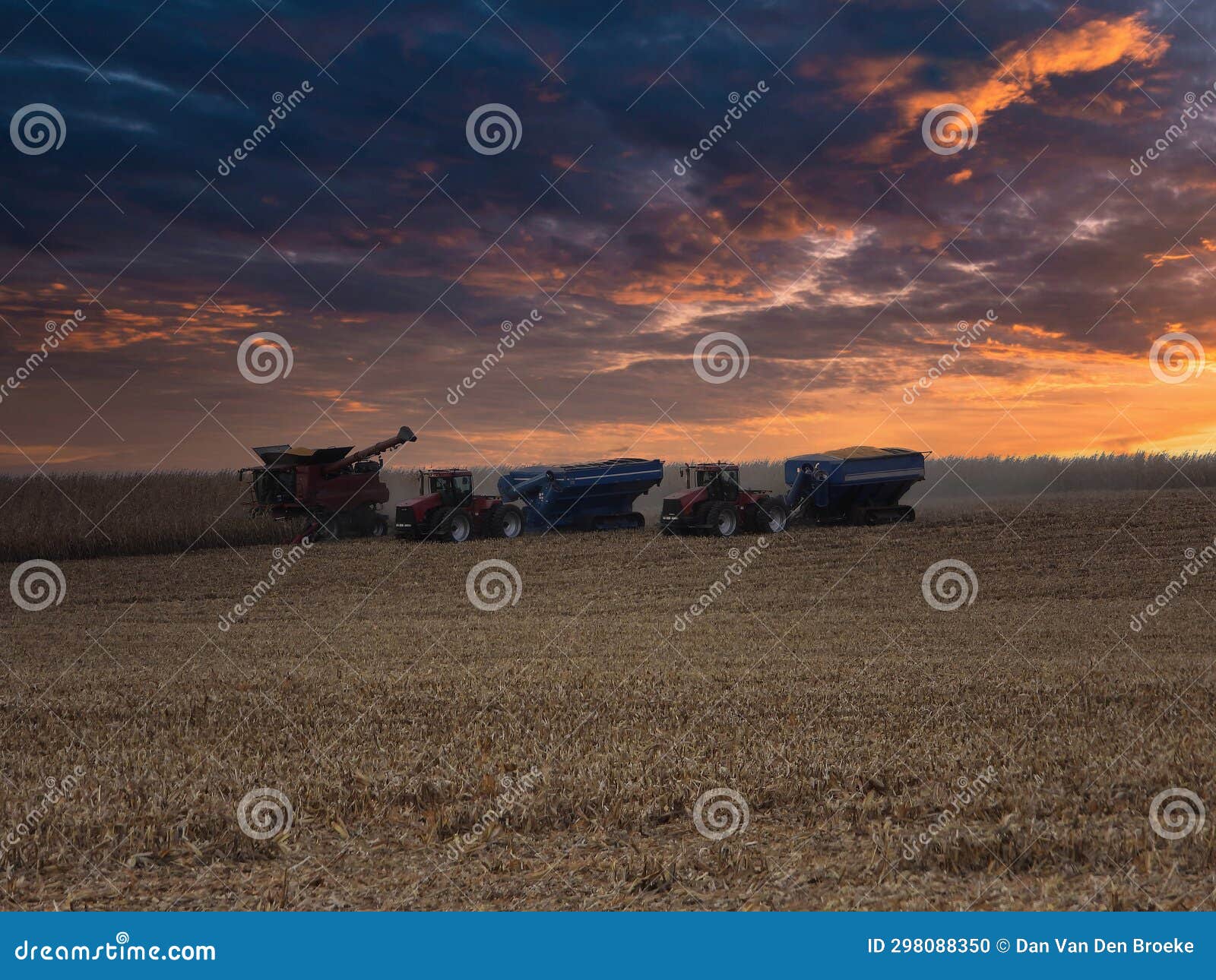 Two Large Tractors Pulling Grain Carts Catching Up To a Harvester To ...