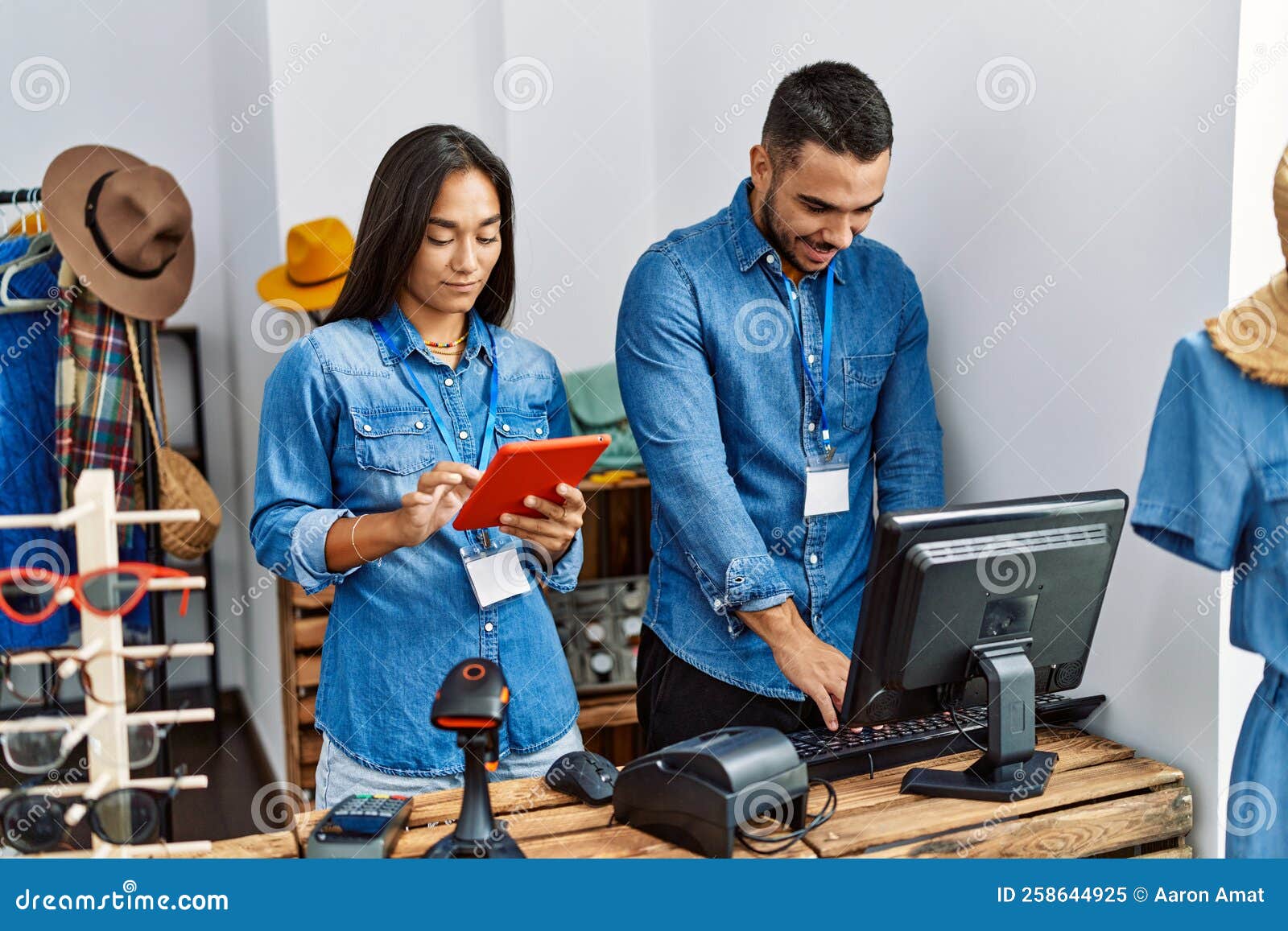 Two Latin Shopkeepers Using Touchpad Working at Clothing Store Stock ...