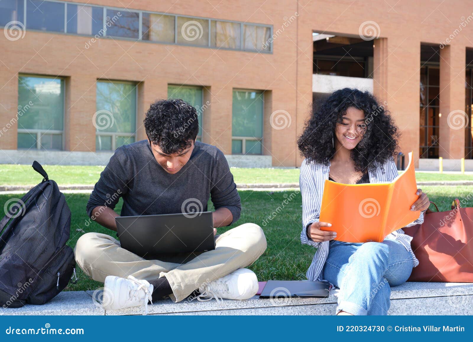 Two Latin Students Studying from Their Lecture Notes Sitting on a Wall ...