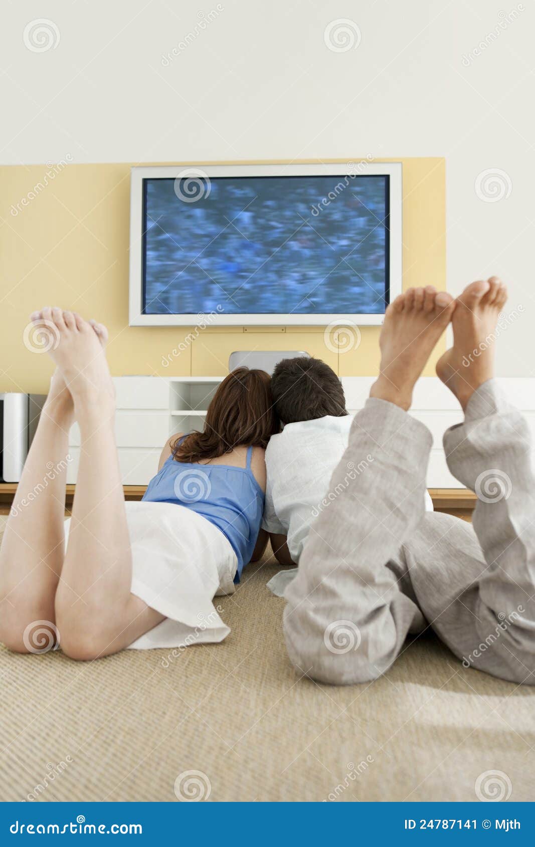 Two Laying Down on Floor Watching TV Stock Image - Image of neutral ...