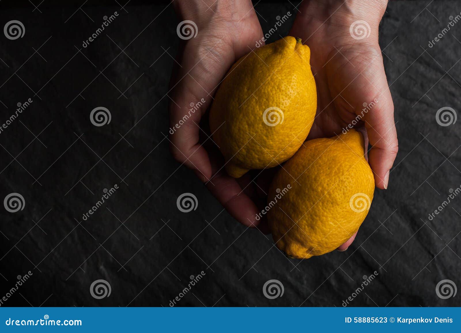 Two Lemons in the Hands on the Black Stone Table Stock Image - Image of ...