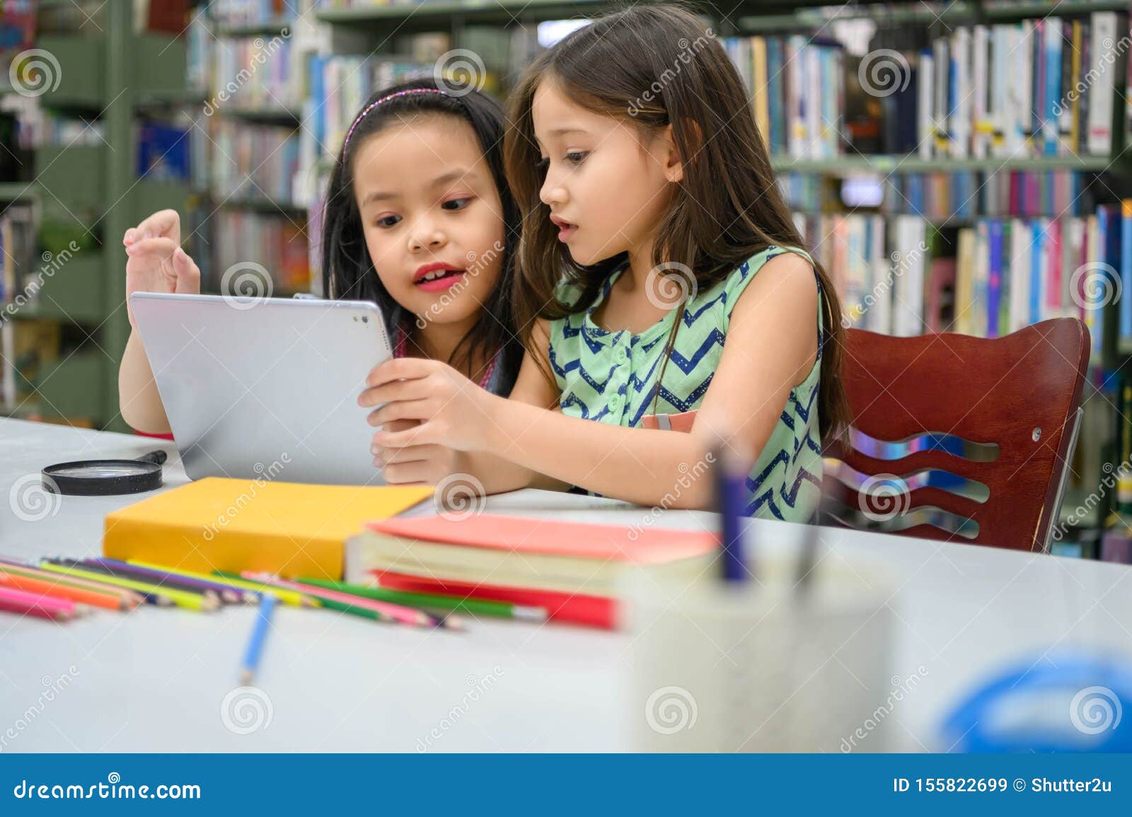 Two Little Happy Cute Girls Playing on a Tablet PC Computing Device in ...