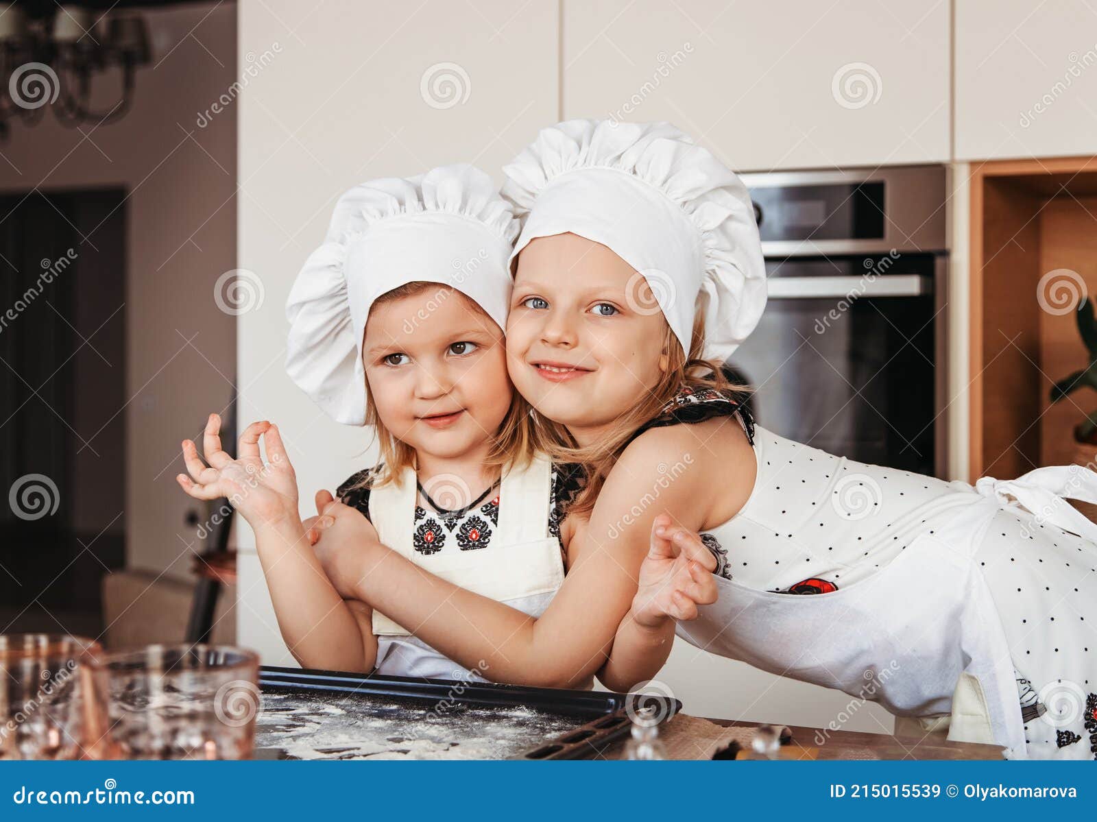 Two Little Sisters Cuddle in the Kitchen in White Chef Hats. Hilarious ...