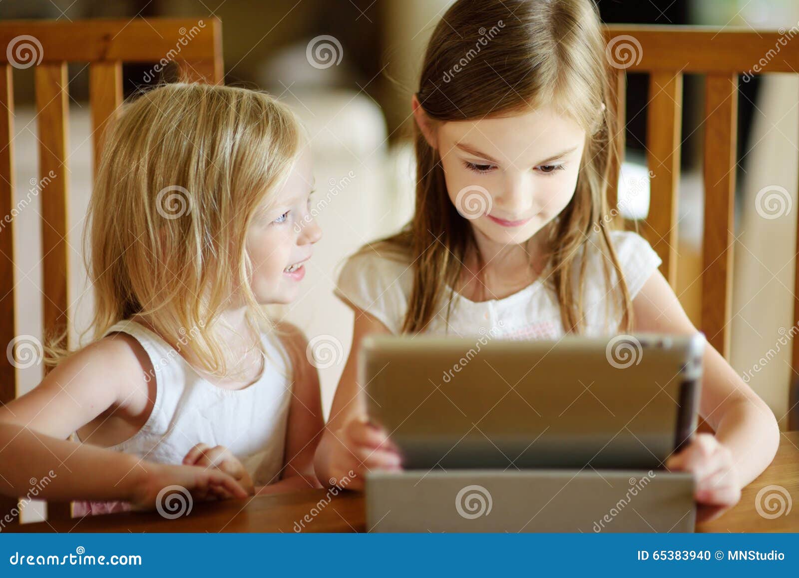 Two Little Sisters Using Digital Tablet Computer Stock Photo - Image of ...