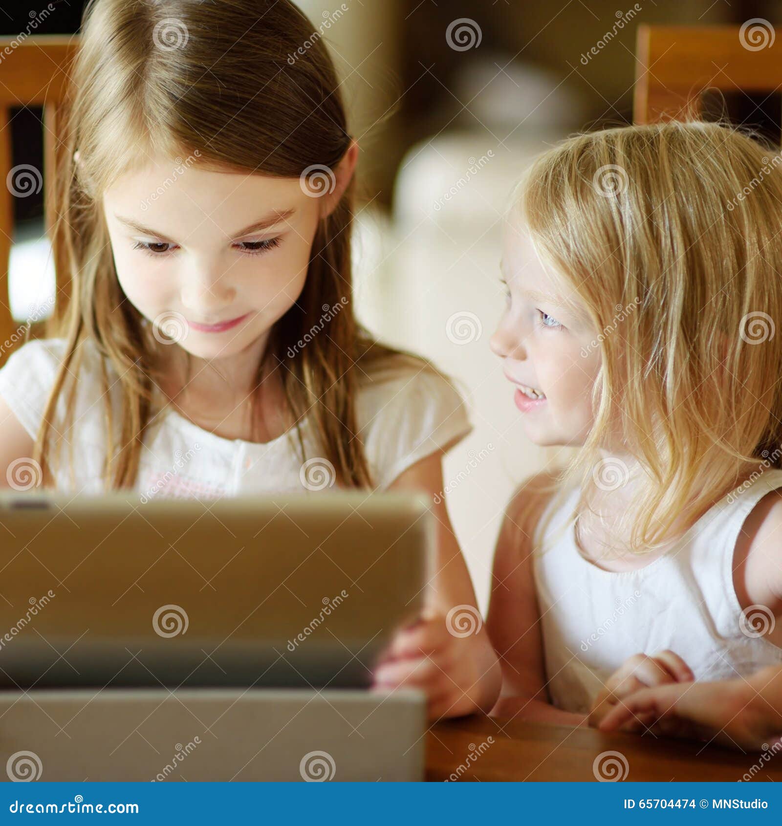 Two Little Sisters Using Digital Tablet Computer Stock Photo - Image of ...