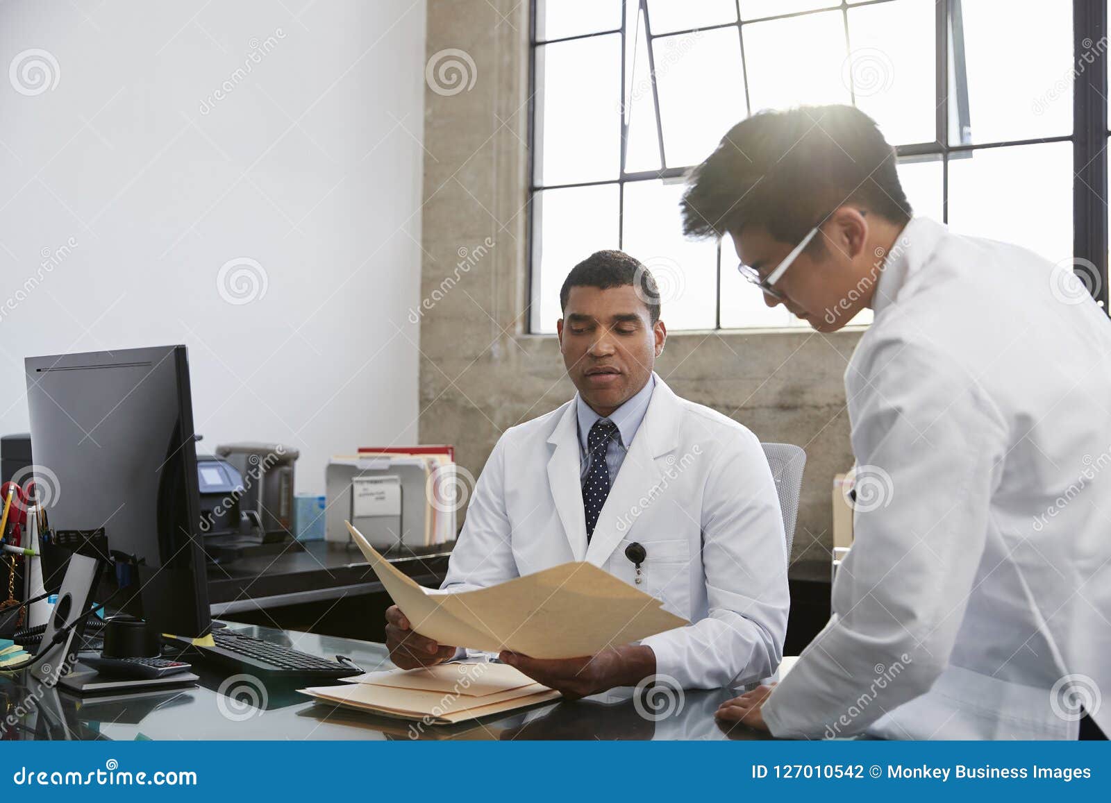 Two Male Doctors in Consultation at Desk in Office Stock Photo - Image ...